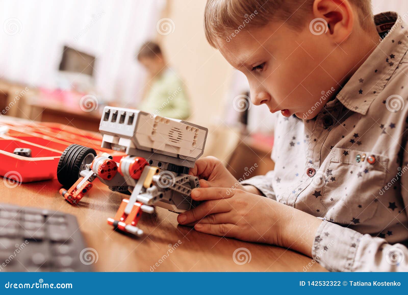 Sedulous Boy Dressed in Gray Shirt Makes a Robot from the Robotic ...