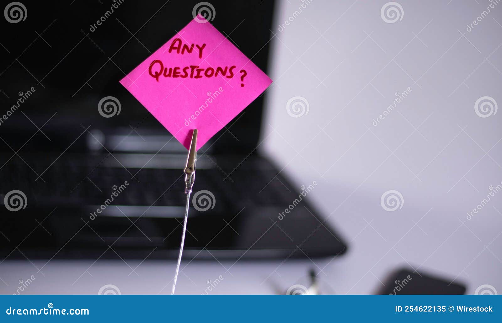 Selective Focus of "Any Questions" Written on a Pink Sticky Note at the ...