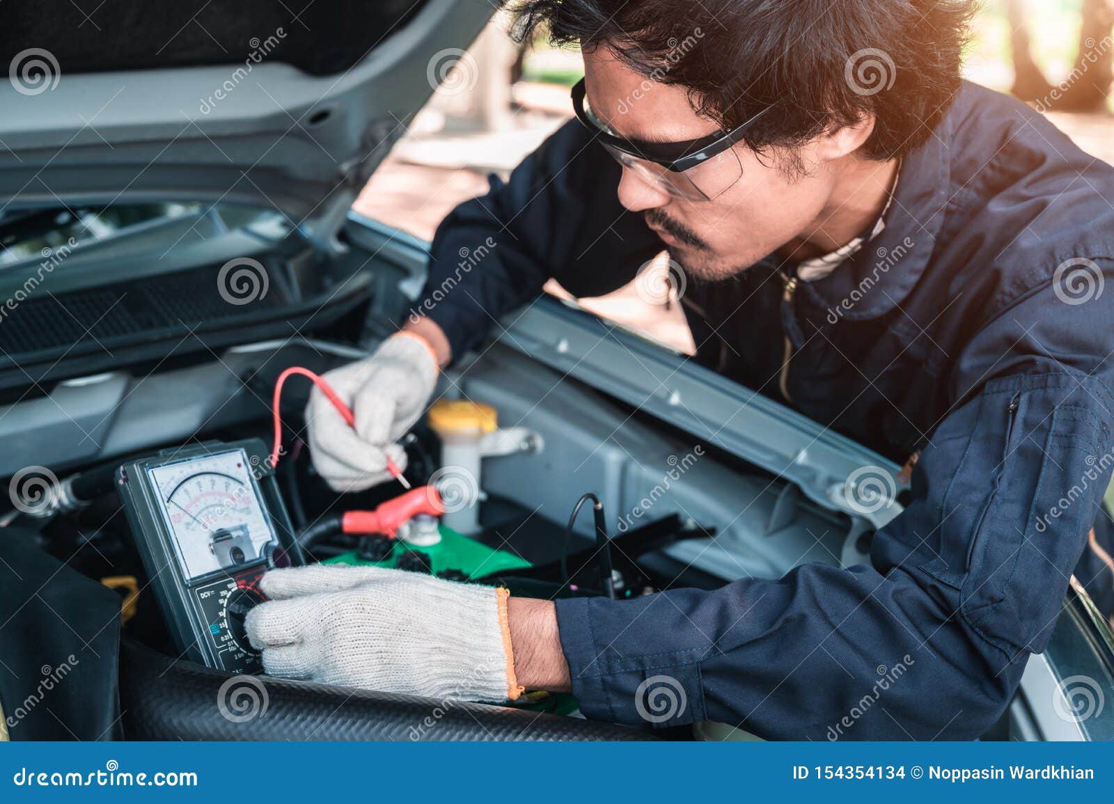 Selective Focus an Auto Mechanic Uses a Multimeter Voltmeter To Check ...