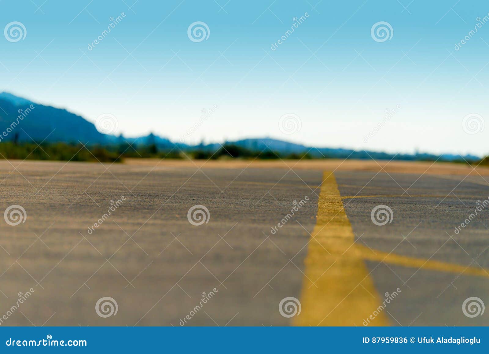 Selective Focus on an Empty Airfield Runway with Yellow Direction Lines ...