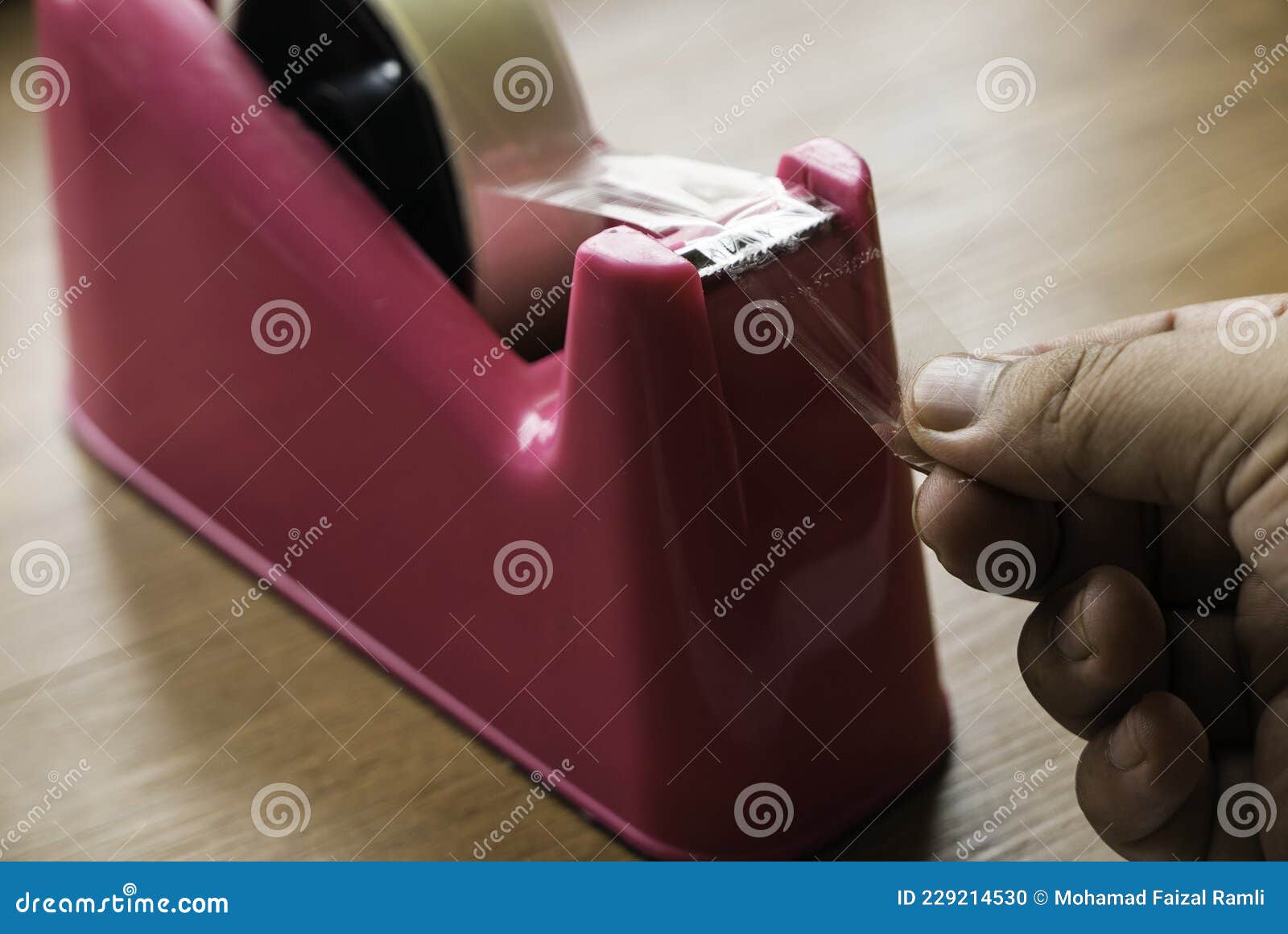 Selective Focus of Hand Pulling a Transparent Tape from a Tape ...