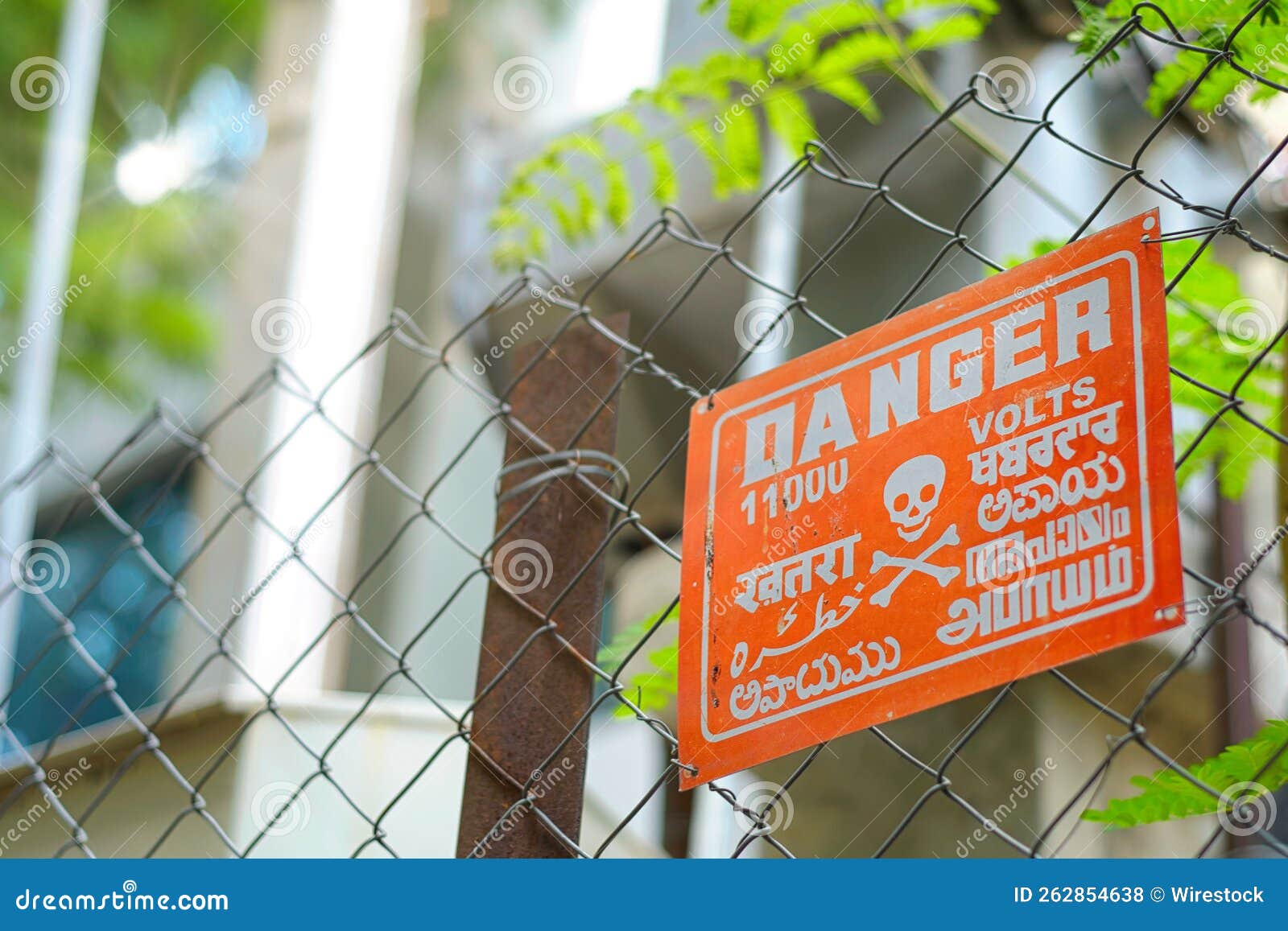 Selective Focus of a High Voltage Warning Signboard on a Fence in Front ...