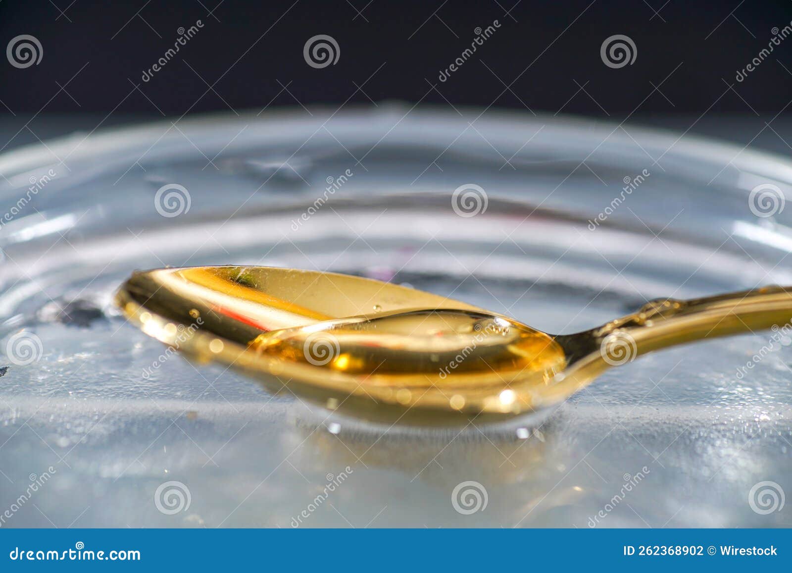 Selective Focus Shot of Golden Spoon with Water Stock Photo - Image of ...