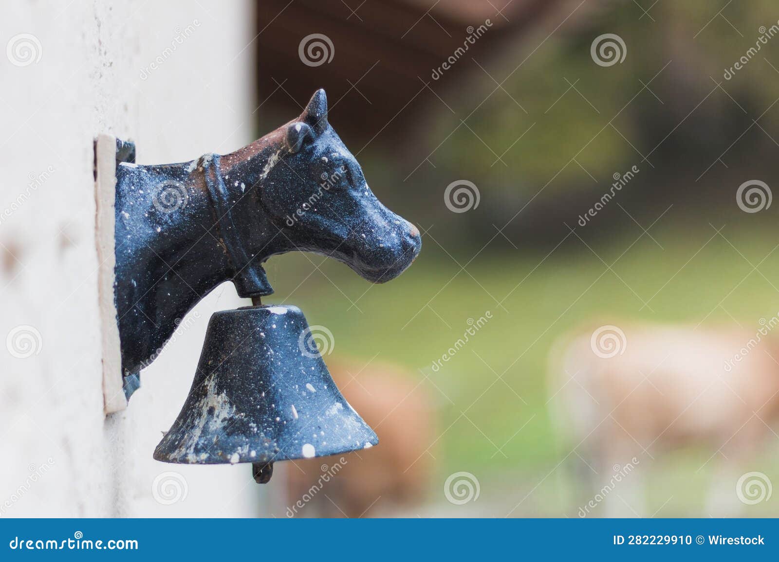 Selective Focus Shot of a Metal Cow-shaped Bell on the Side of a Barn ...