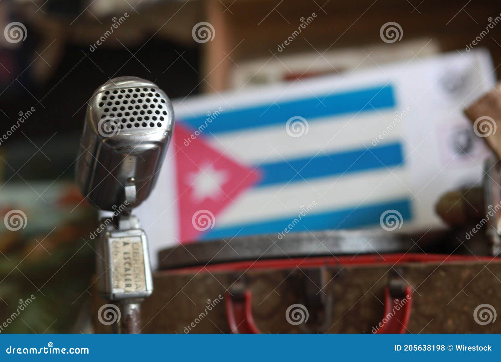 Selective Focus Shot of an Old Microphone with a Blurry Cuban Flag ...