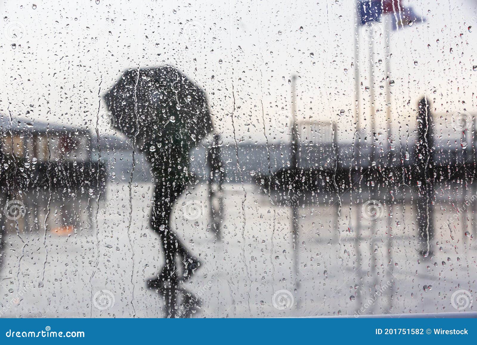 Selective Focus Shot of a Wet Window with a View of People with ...
