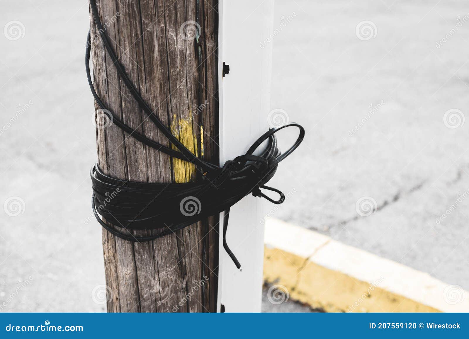 Selective Focus Shot of a Wooden Pillar with Black Wire Winded Around ...