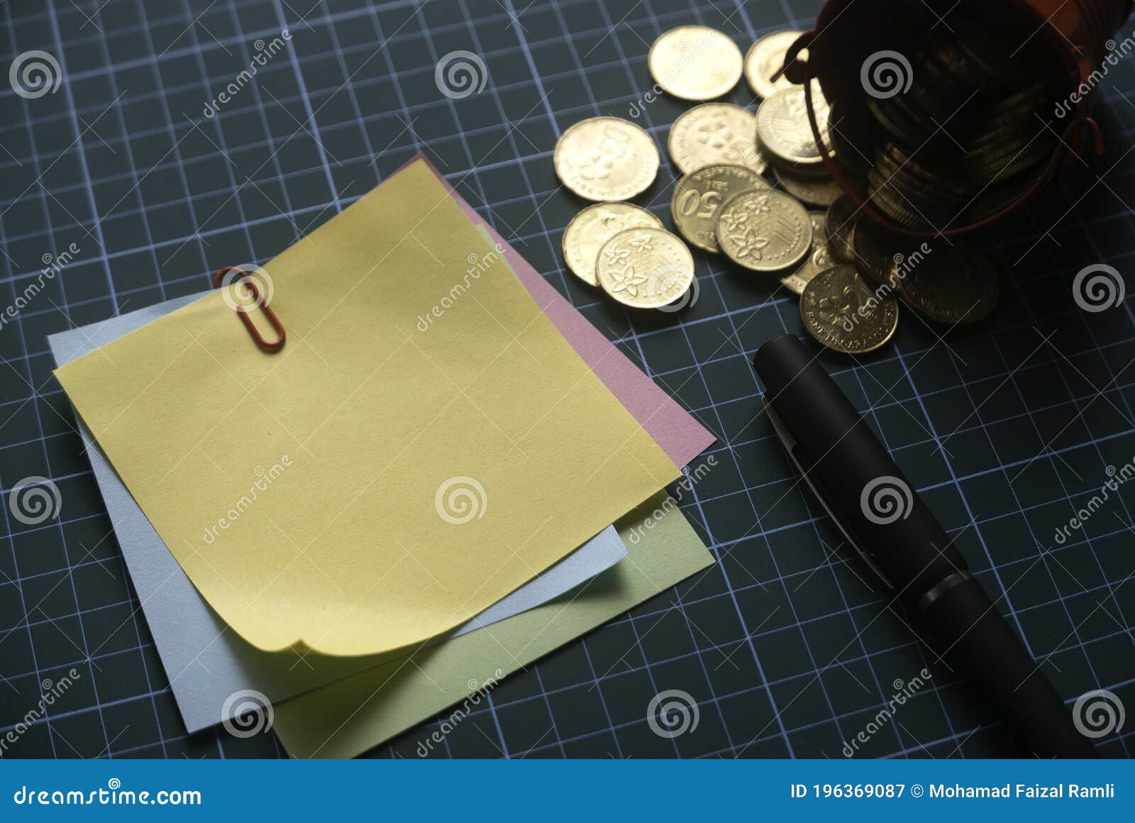Selective Focus of Stack of Memo Note with Red Bucket of Gold Coins and ...