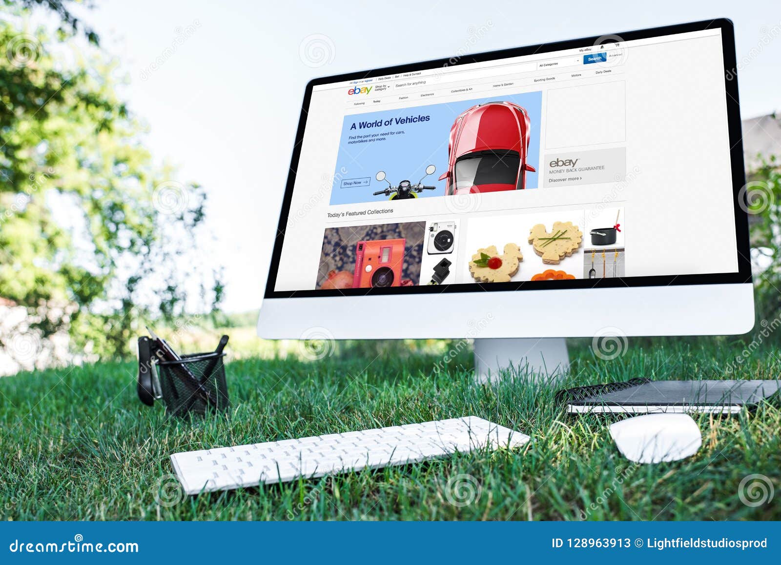 Selective Focus of Textbook and Computer with Ebay Website on Grass ...