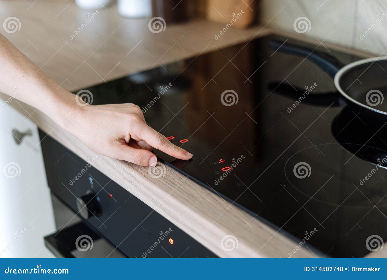 Selective Focus on Woman Hand Pressing on Digital Control Panel of Induction Cooker in Kitchen ...