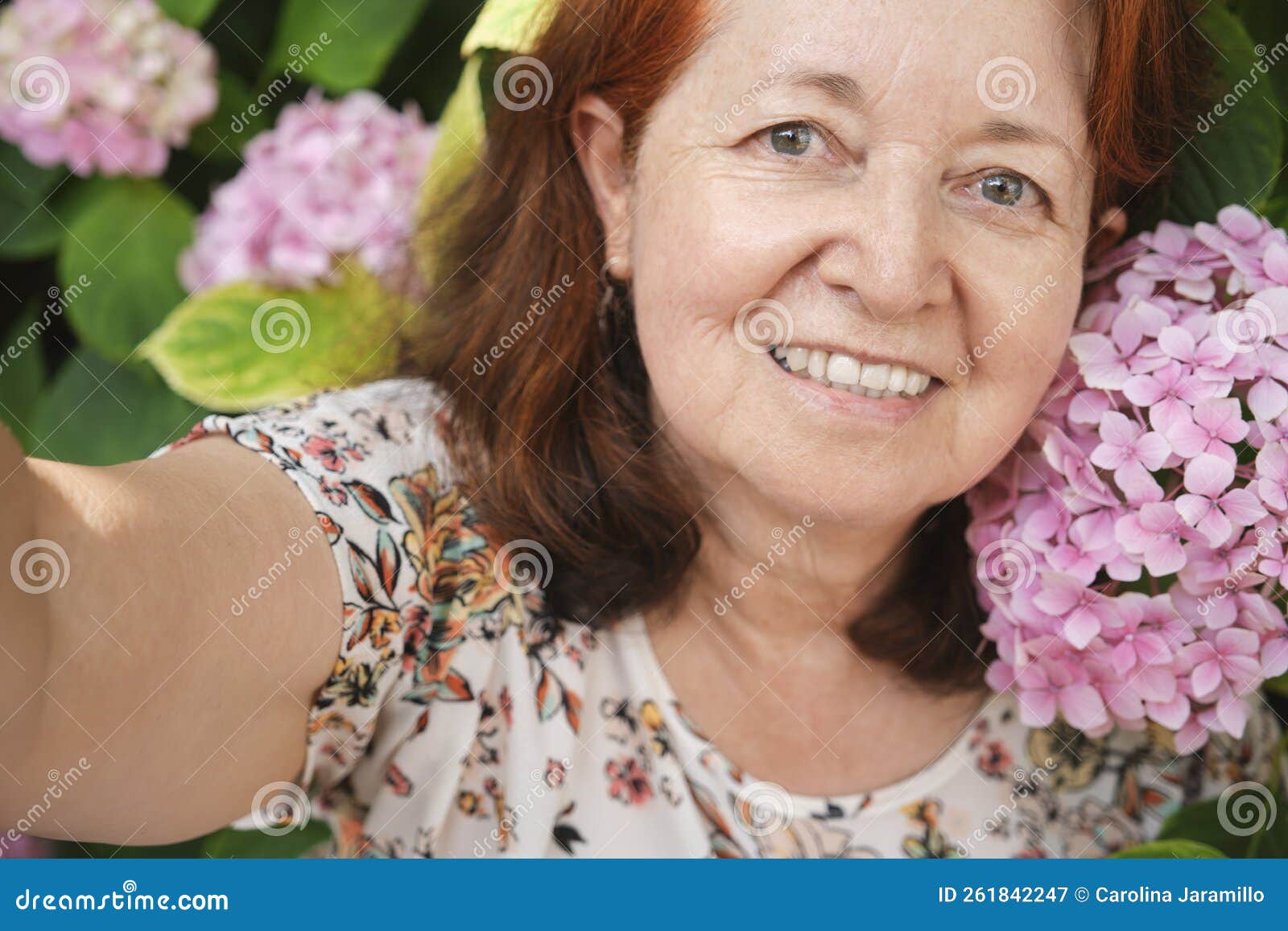 Selfie Of A Happy Mature Hispanic Woman In A Garden Surrounded By Pink