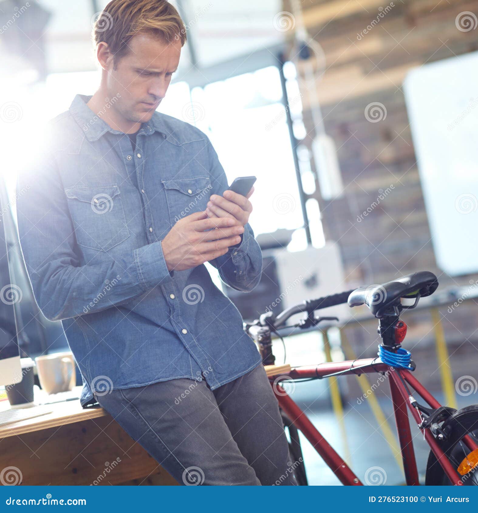 Sending a Quick Text Message. Designer Using a Cellphone while at Work ...