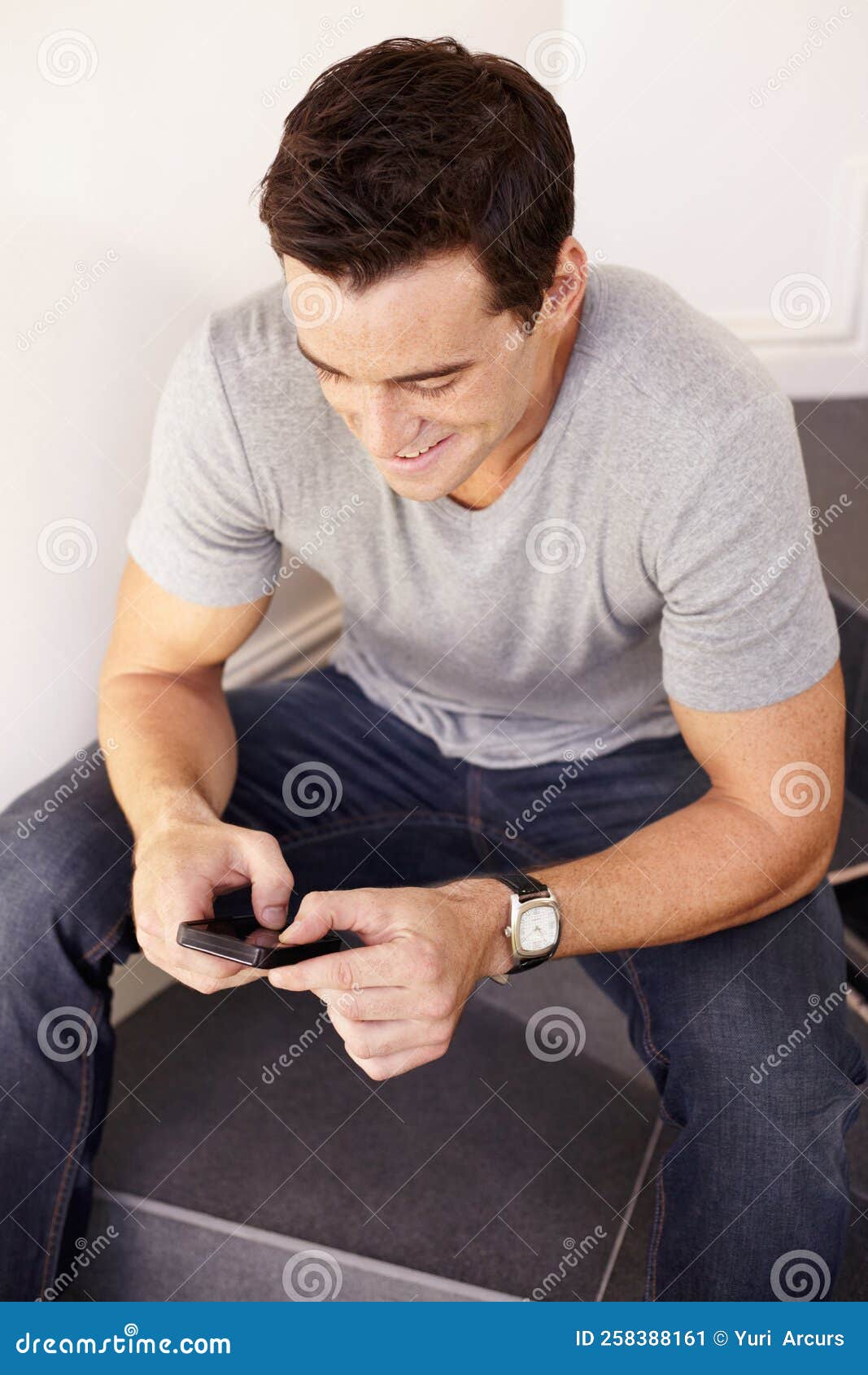 Sending a Text. a Handsome Young Man Sending a Text Message on His ...