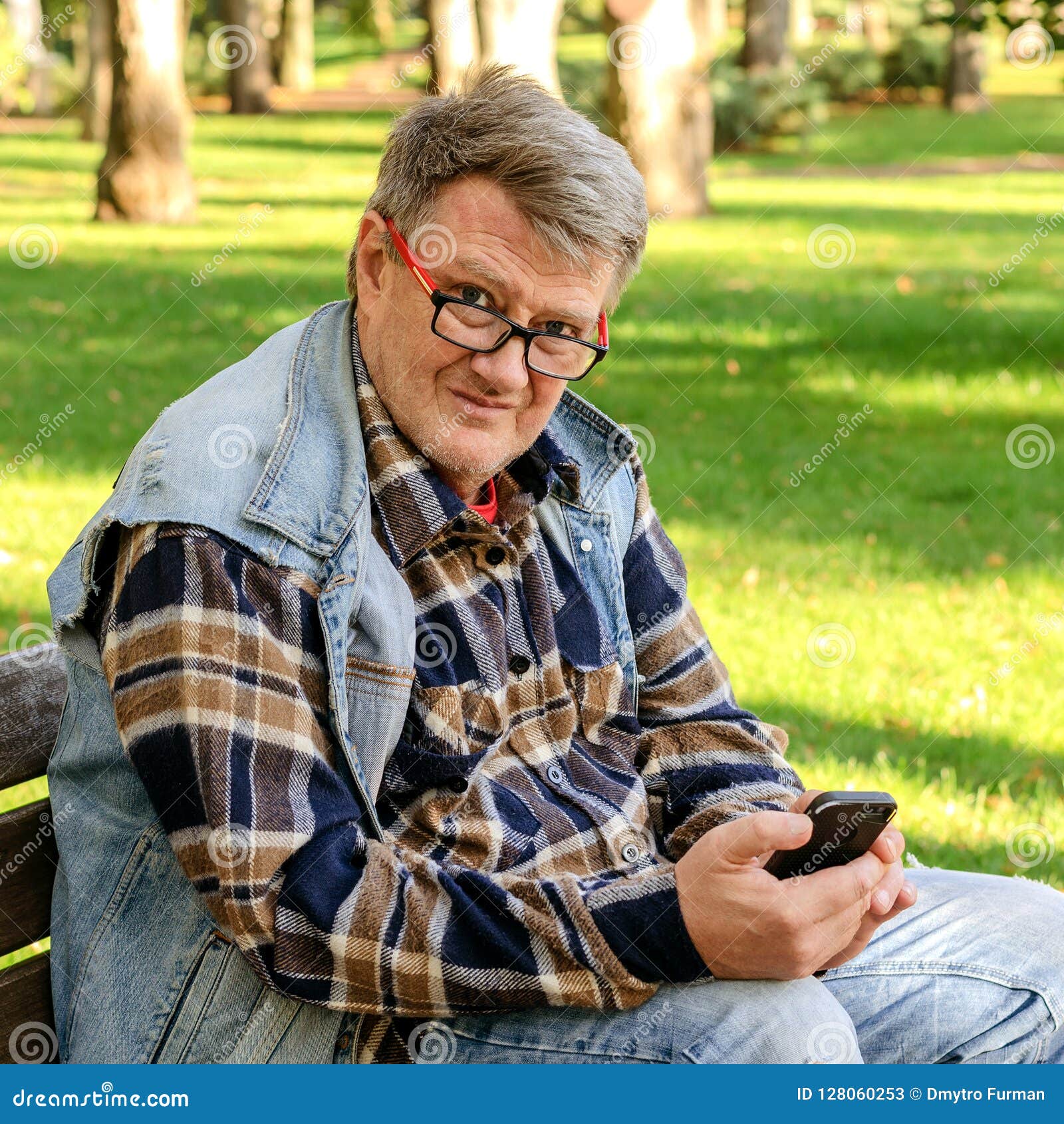 Senior Adult Man In Casual Clothing And A Eyeglasses Sits On A Stock