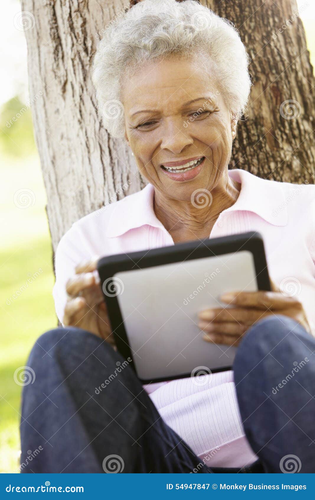 Senior African American Woman in Park Using Tablet Computer Stock Image ...