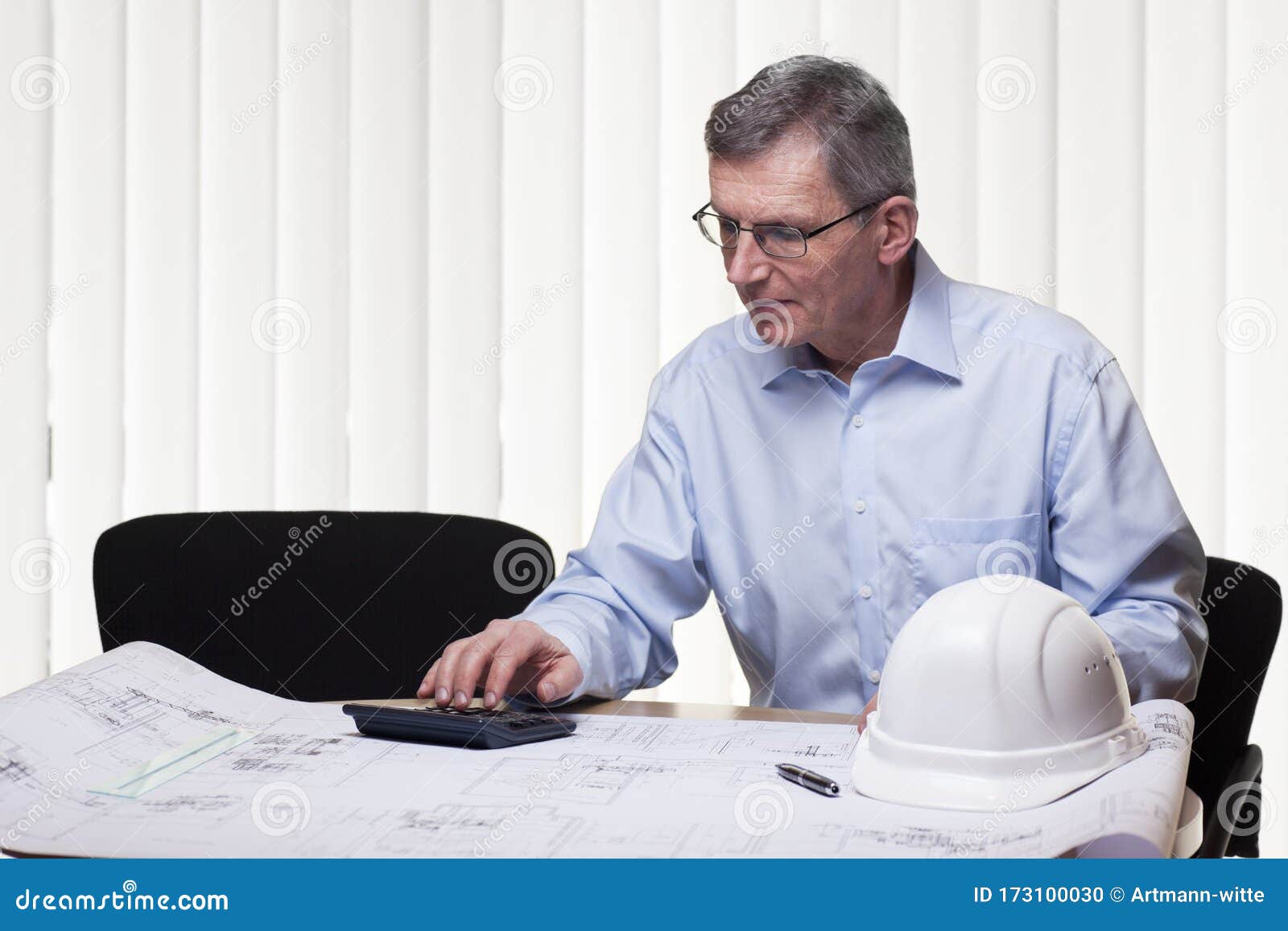 Senior Architect or Engineer Calculating a Project in an White Office ...