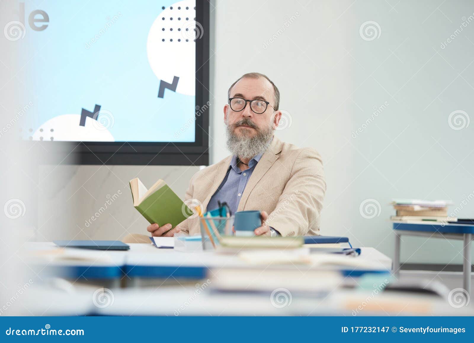 Bearded Professor At School Lesson At Desks In Classroom. Back To ...
