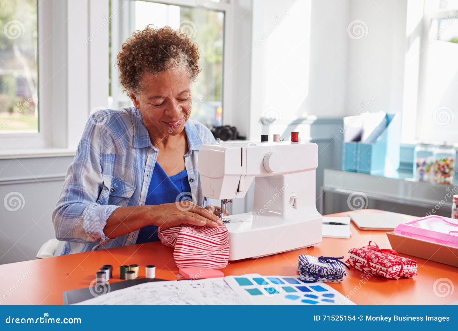 Senior Black Woman Stitching Fabric Using A Sewing Machine Stock Photo ...