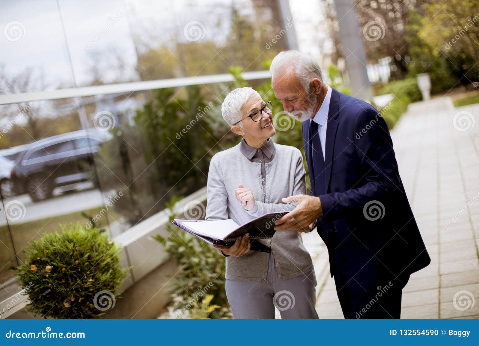 Senior Business People Talking Outdoors and Discussing a Document Stock ...