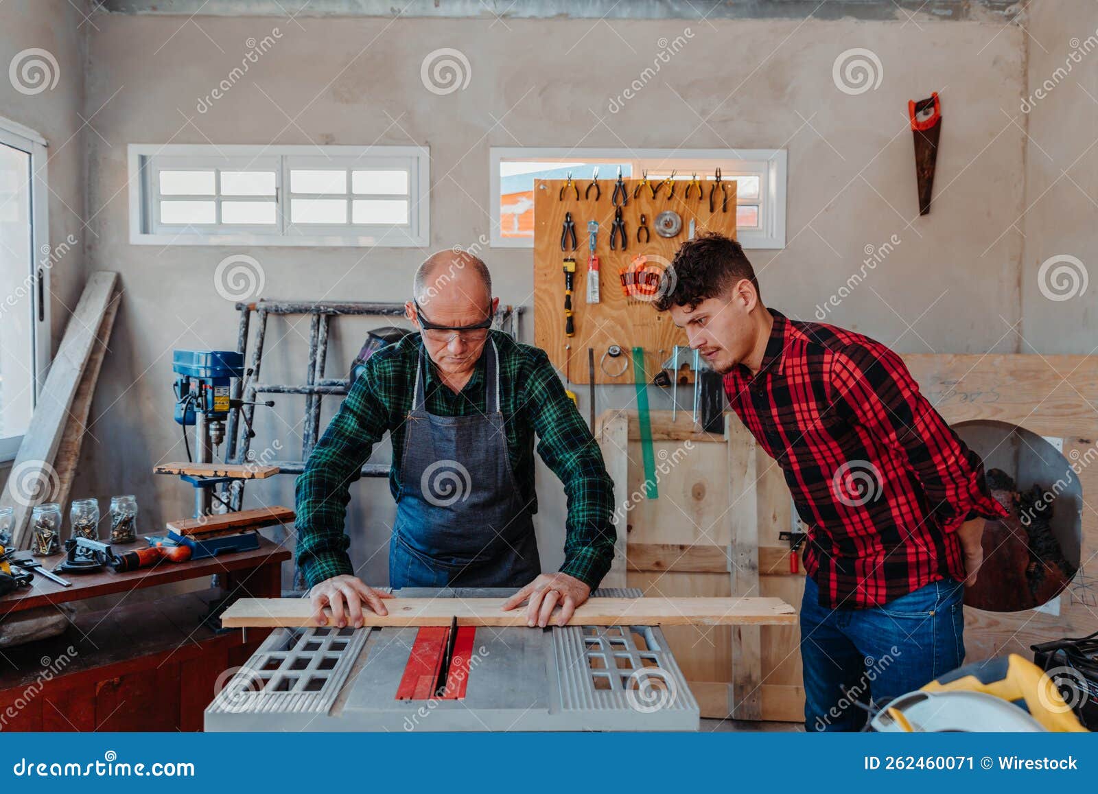Senior Carpenter Teaching a Younger Man How To Work Stock Image - Image ...