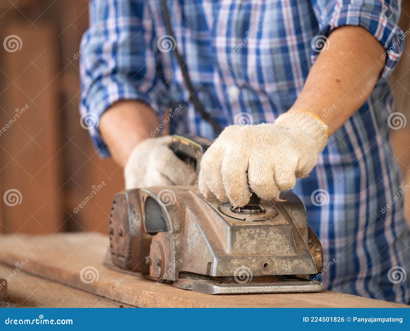 Senior Carpenter Using an Electric Planer with a Wooden Plank in the ...