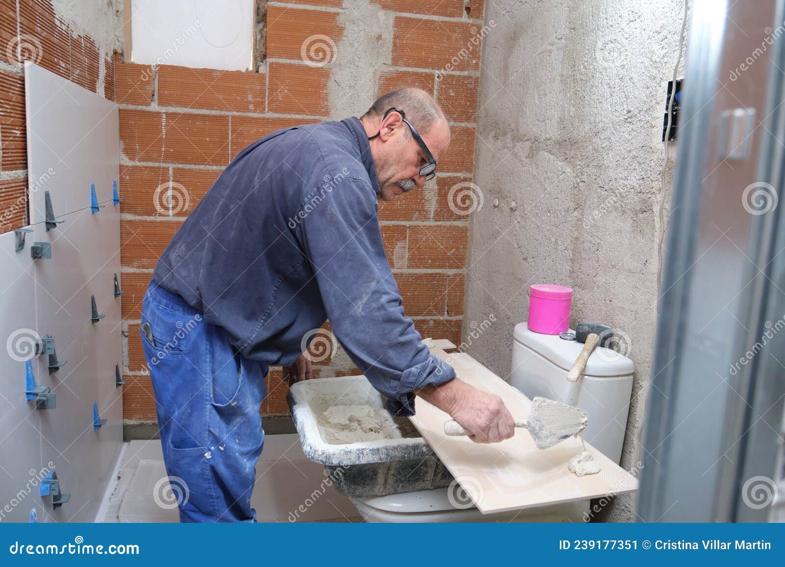 Senior Constructor Worker Adding Tile Adhesive Mortar To the Tile ...