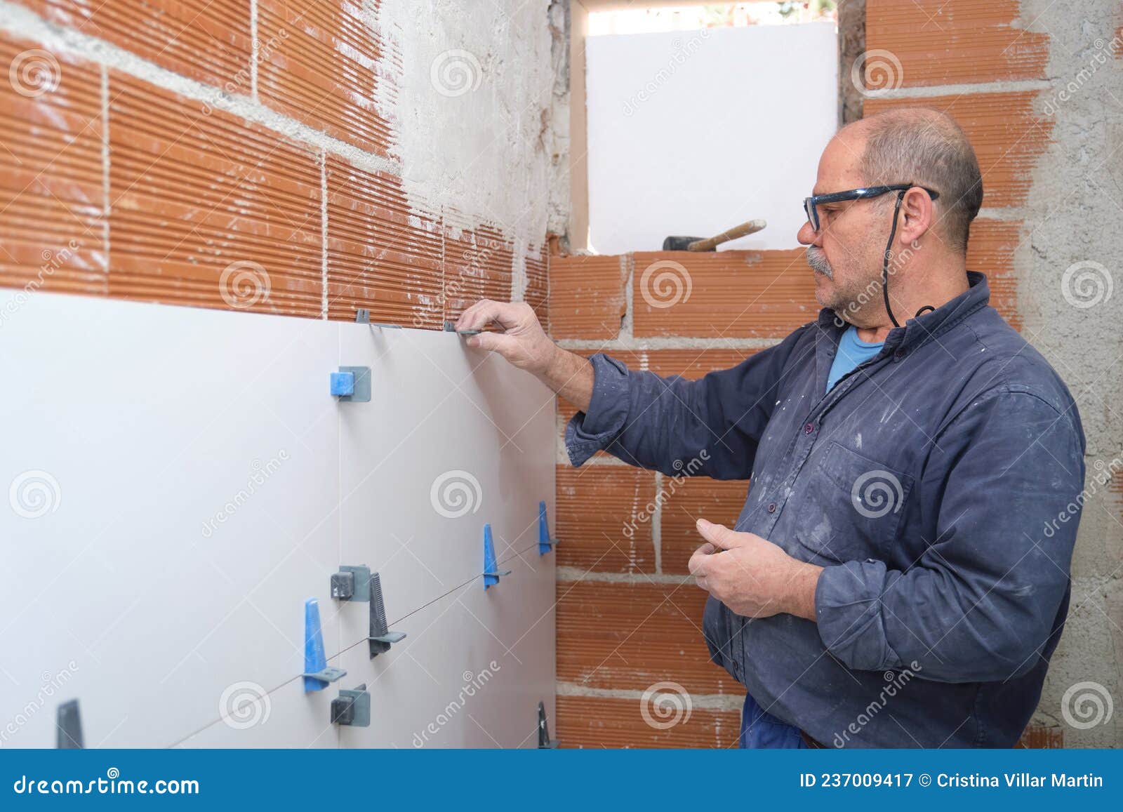 Senior Constructor Worker Adjusting the Separation between Tiles on the ...