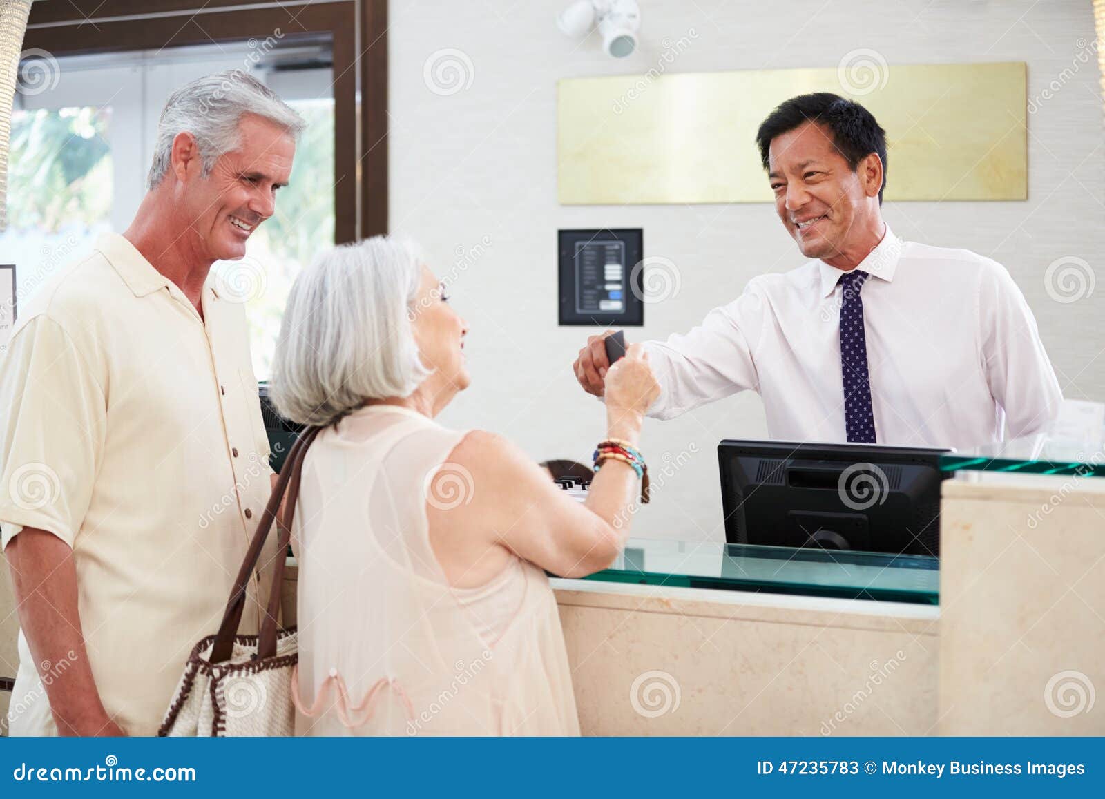 Senior Couple Checking in at Hotel Reception Stock Image - Image of ...
