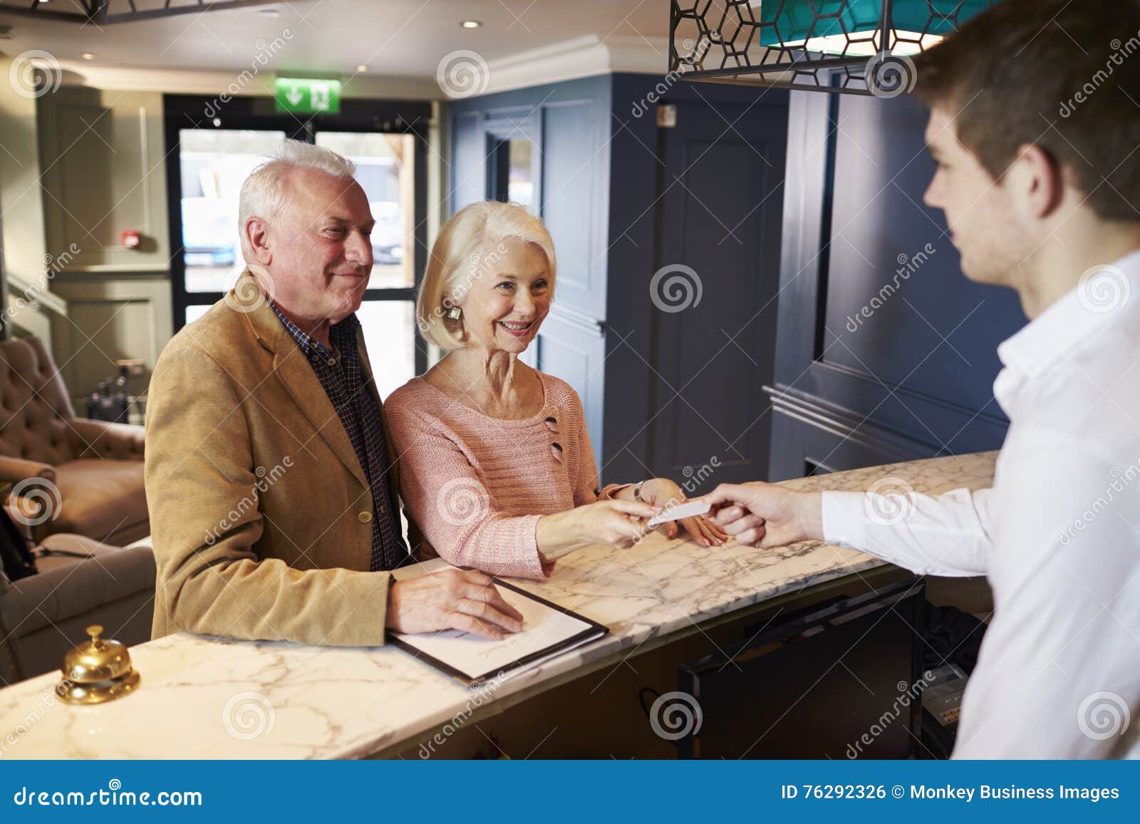 Senior Couple Checking in at Hotel Reception Stock Photo - Image of ...