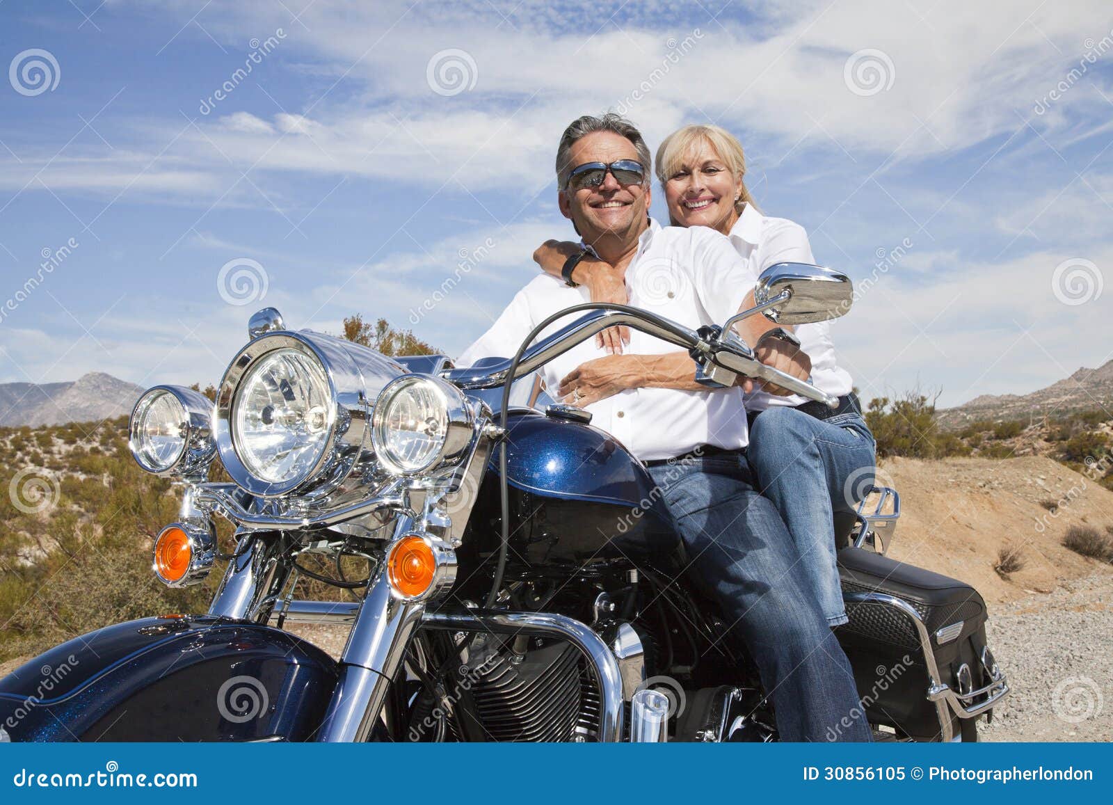 Senior Couple On Desert Road Sitting On Motorcycle Looking At Camera ...