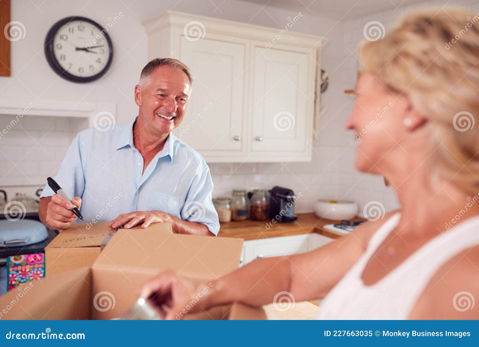 Senior Couple Downsizing in Retirement Packing and Labelling Boxes ...