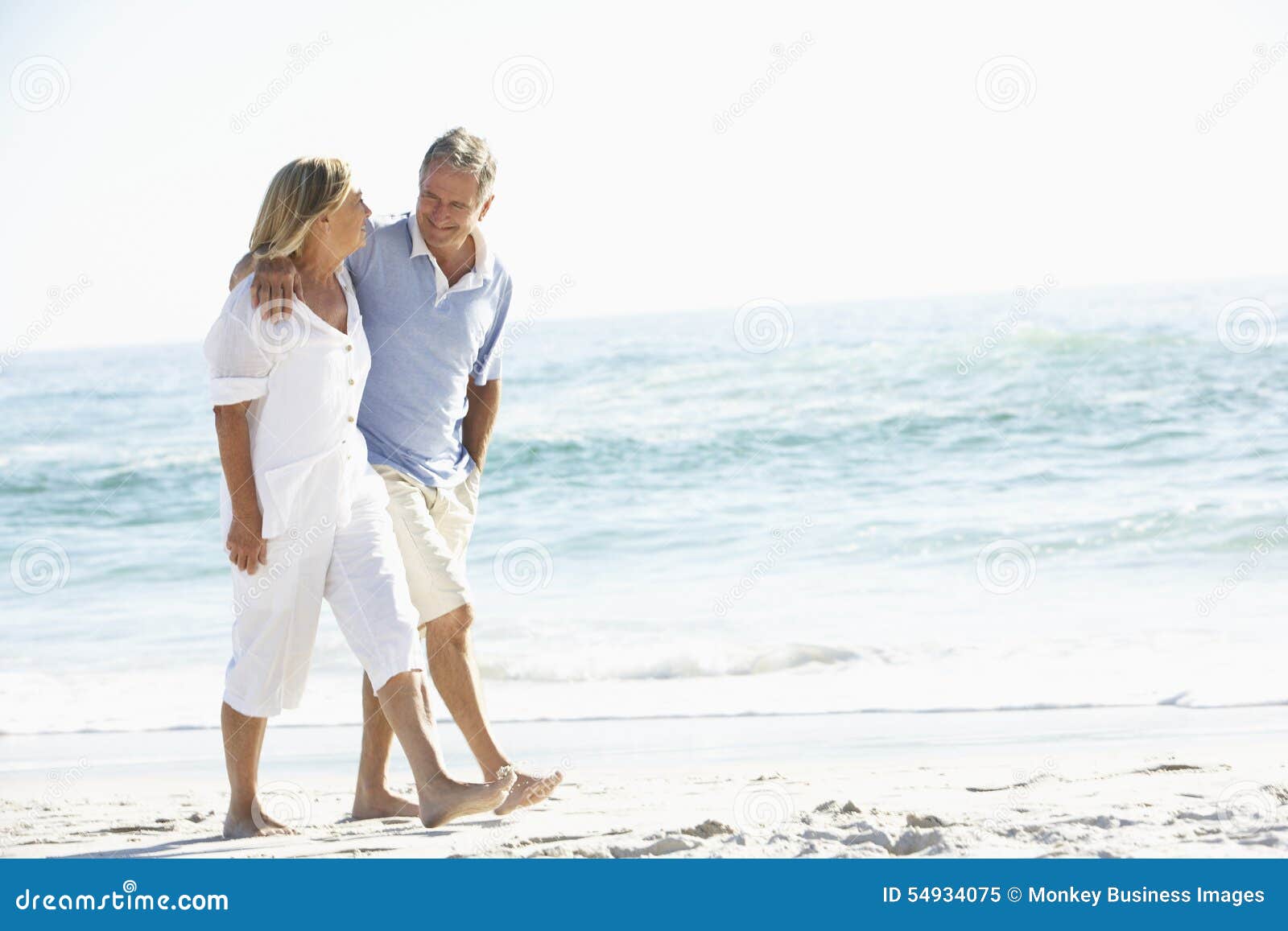Senior Couple on Holiday Walking Along Sandy Beach Stock Image - Image ...
