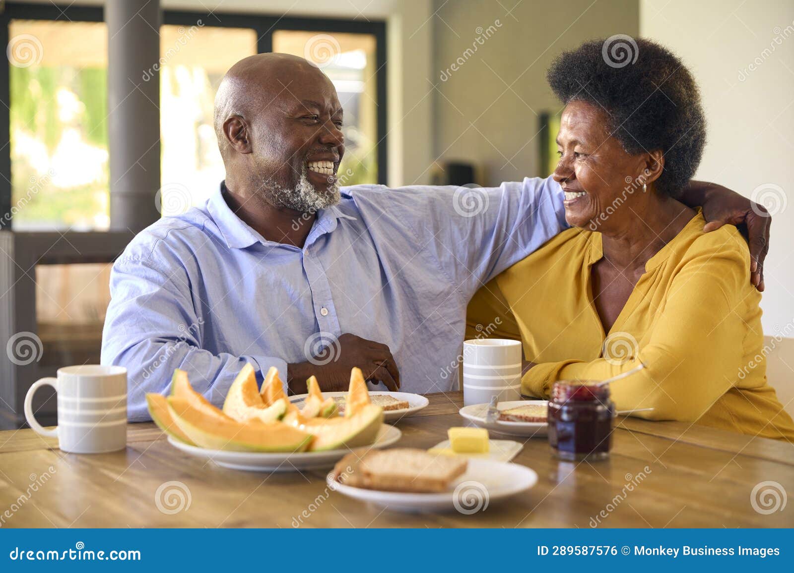 Senior Couple at Home Enjoying Breakfast Around Table Together Stock ...