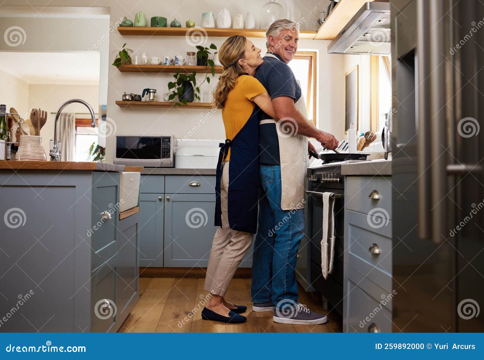 Senior Couple In Kitchen Hug Cooking Healthy Food Together And Care In