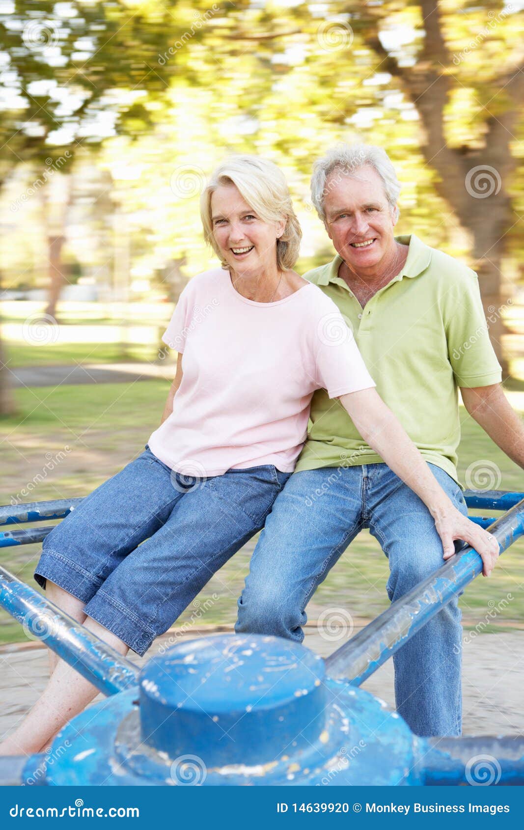 Senior Couple Riding on Roundabout in Park Stock Photo - Image of ...