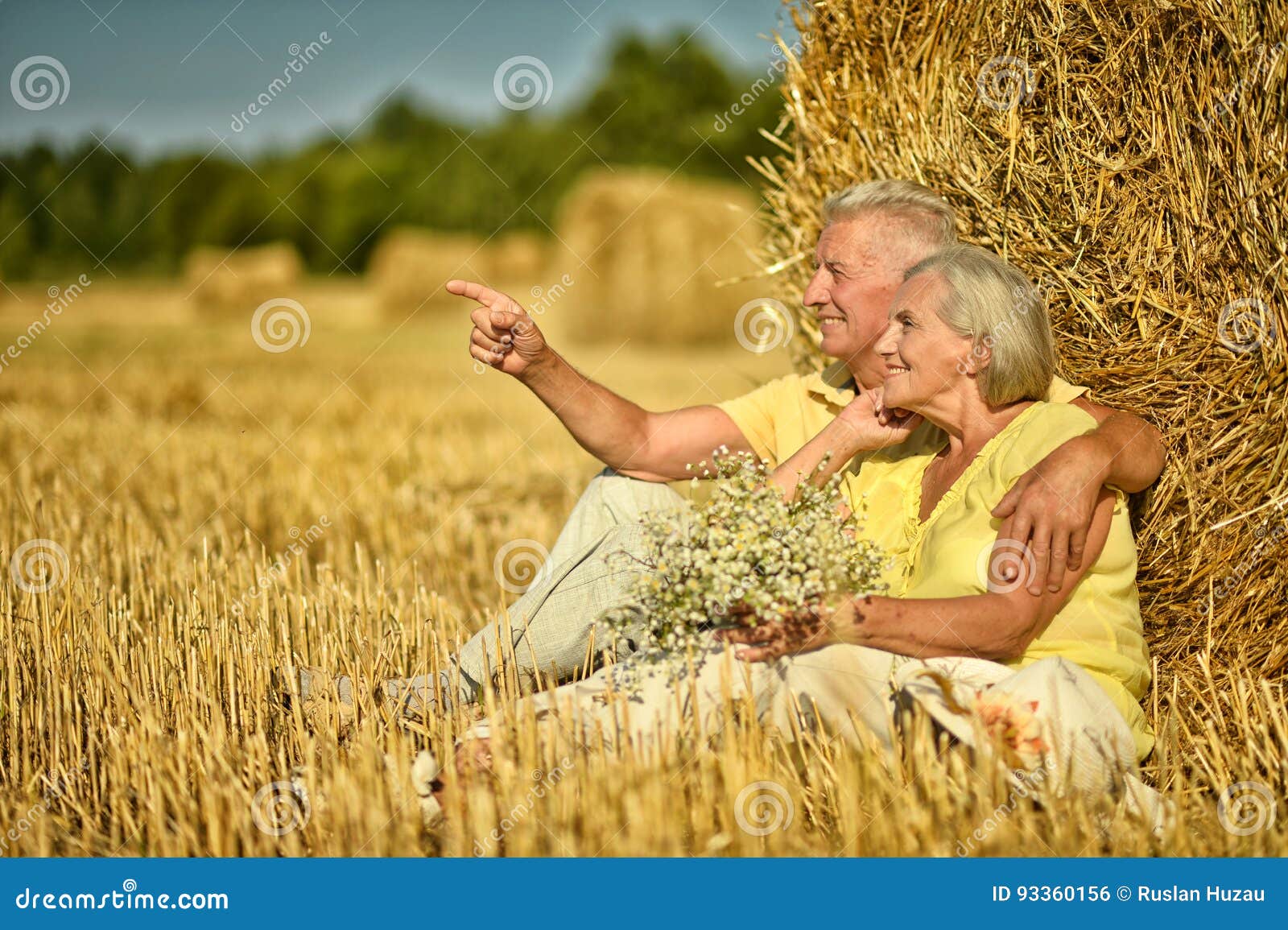 Senior Couple Sitting Near Stack of Hay Stock Photo - Image of field ...