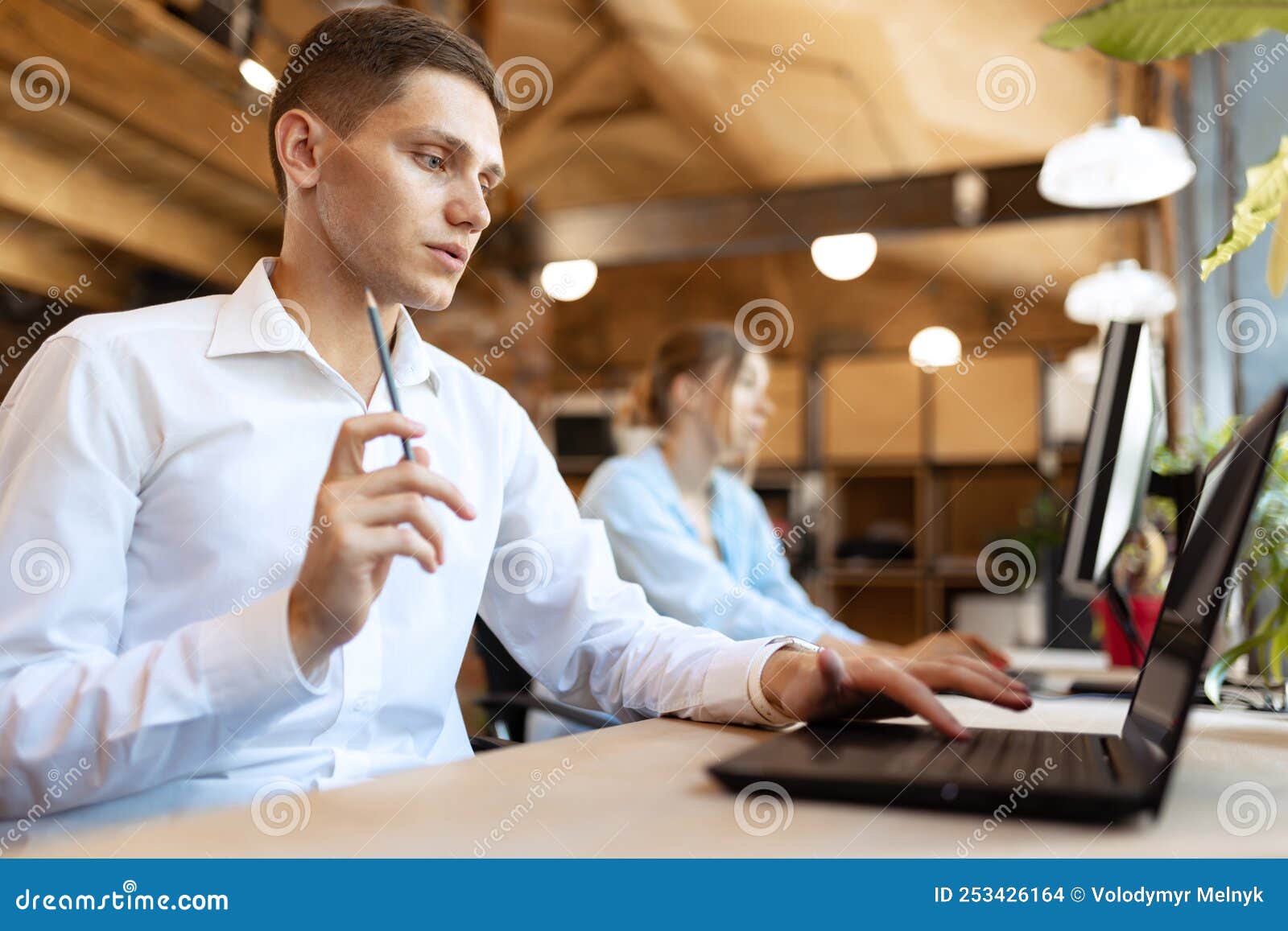 Senior Developer. Young Man Looking at Laptop and Thinking Stock Photo ...