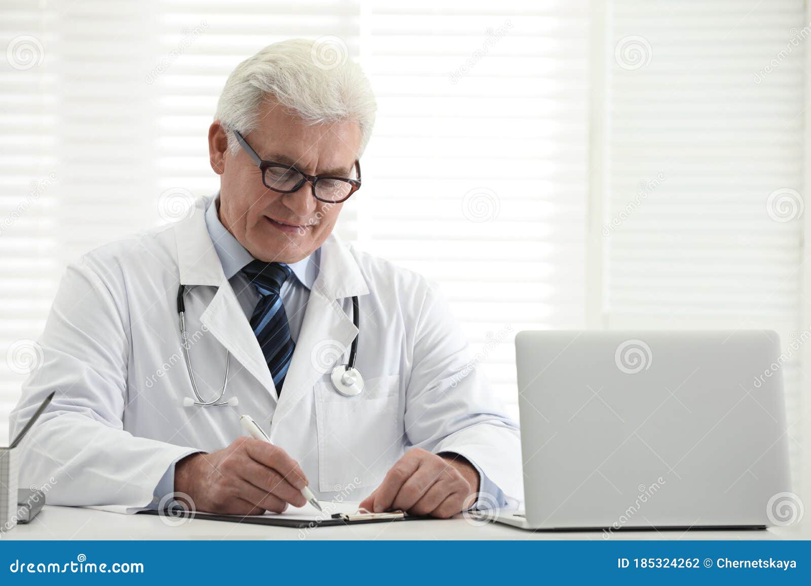 Doctor Working at Table in Office Stock Photo - Image of confident ...