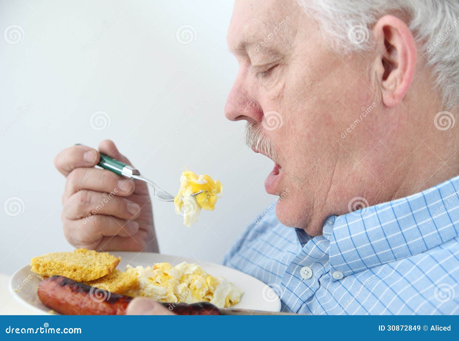 Senior eats breakfast eggs stock image. Image of scrambled - 30872849