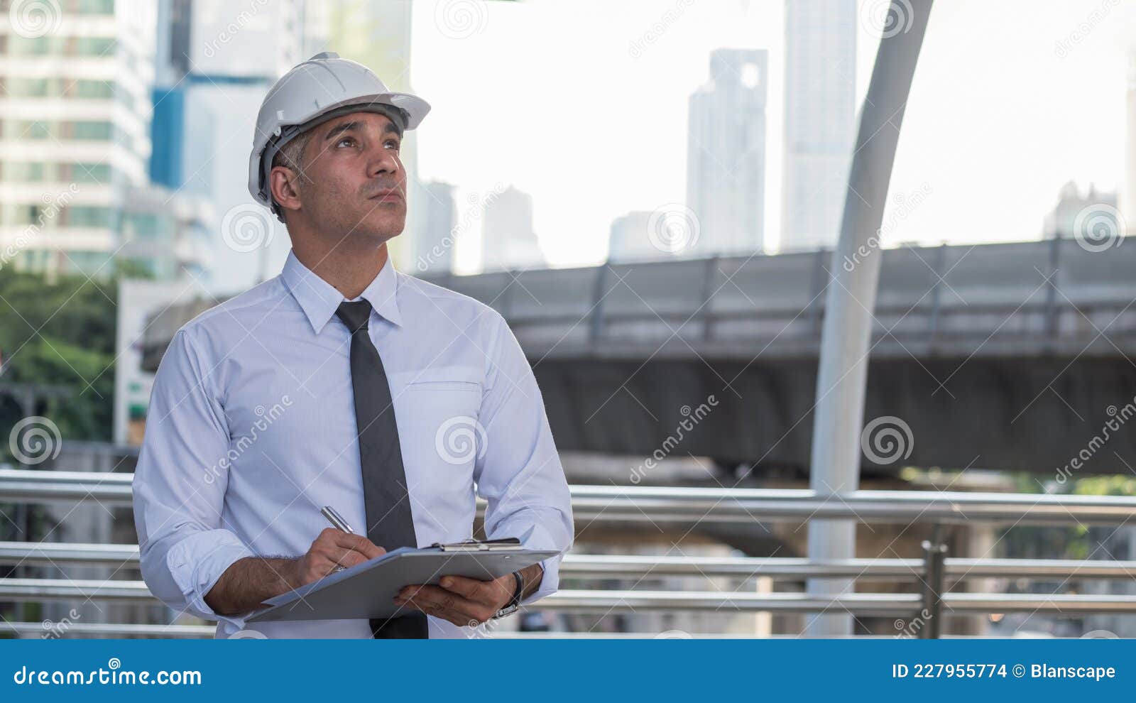 Senior Engineer Manager Take Note on Blueprint in City Stock Photo ...
