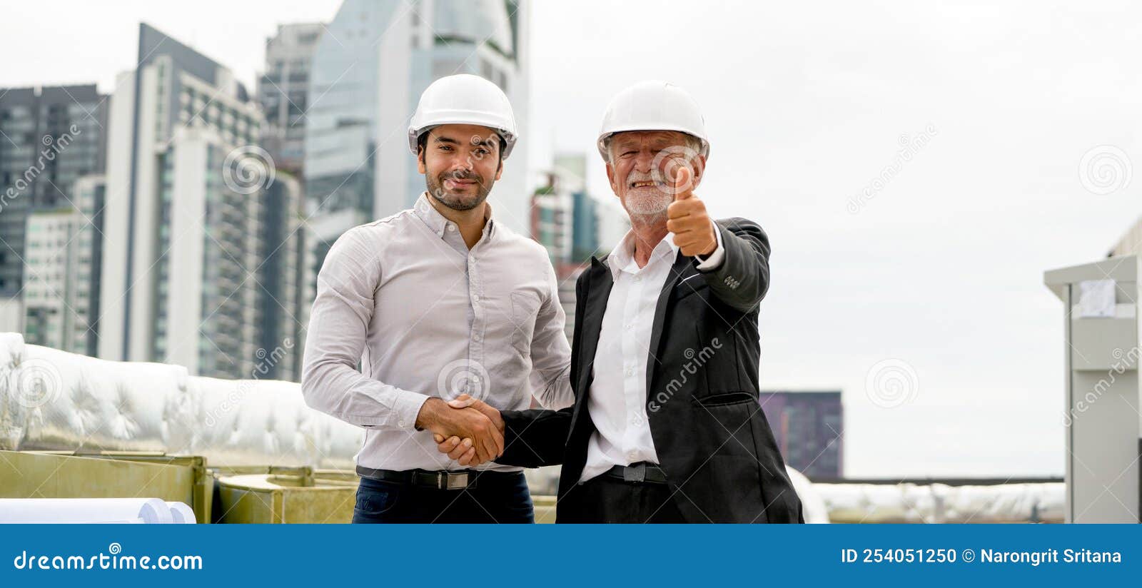 Senior Engineer and Young Worker Shake Hands and Look at Camera and ...