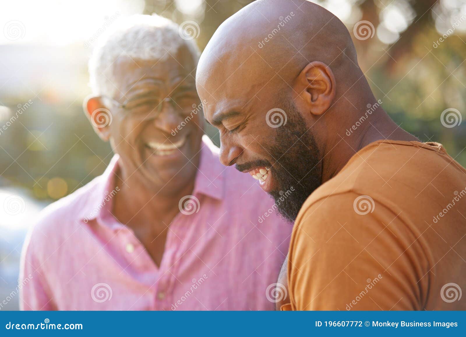Senior Father Talking And Laughing With Adult Son In Garden At Home