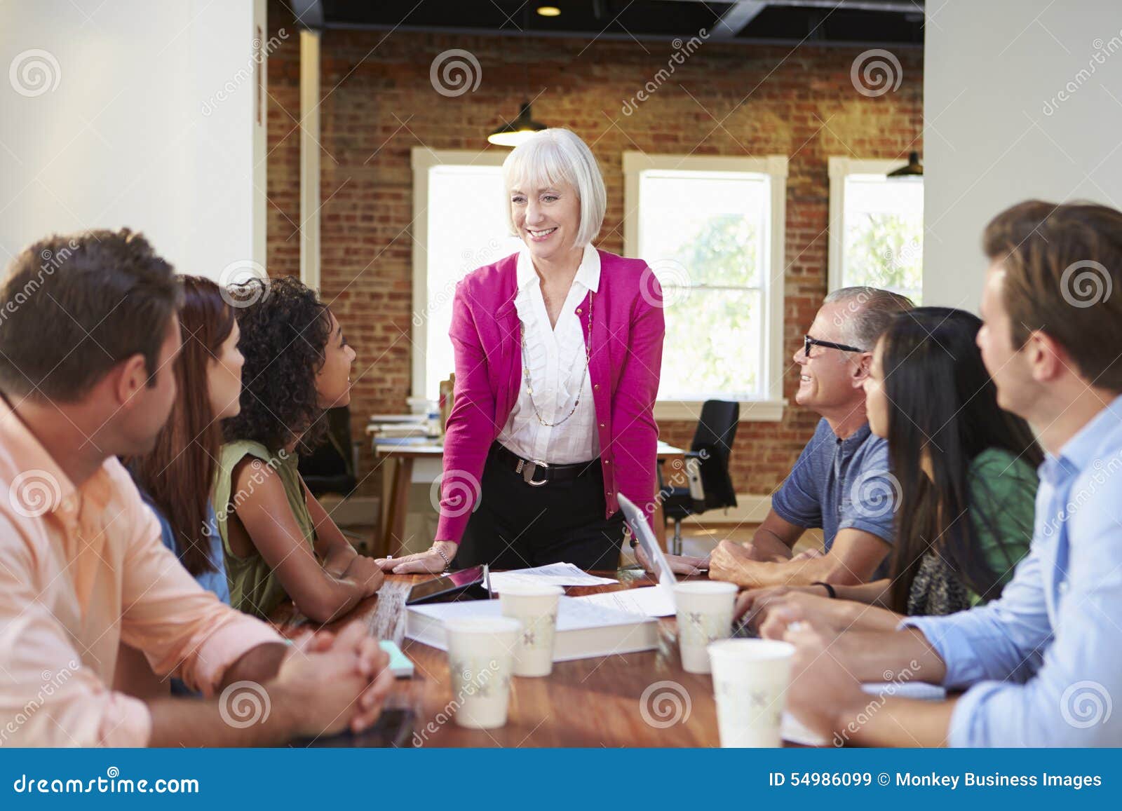 Senior Female Boss Addressing Office Workers at Meeting Stock Image ...