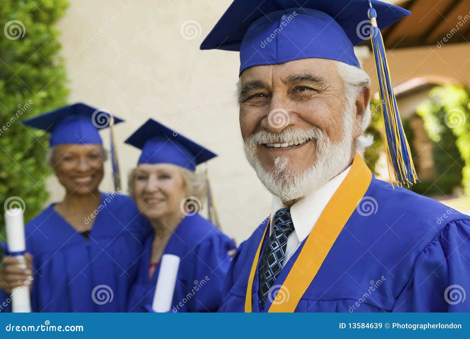 Senior Graduate Smiling Outside with Others Behind Stock Image - Image ...