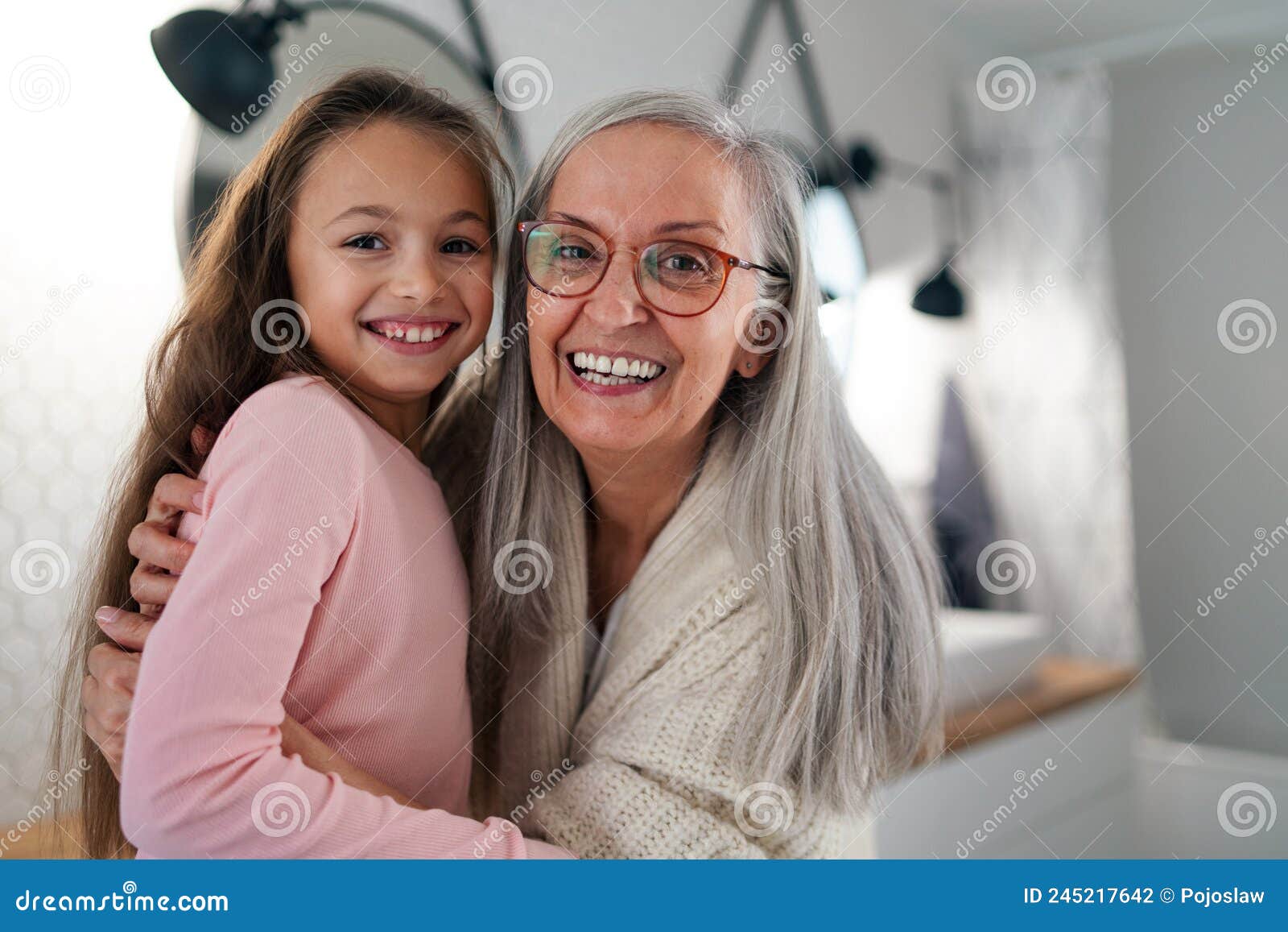 Senior Grandmother And Granddaughter Standing Indoors In Bathroom