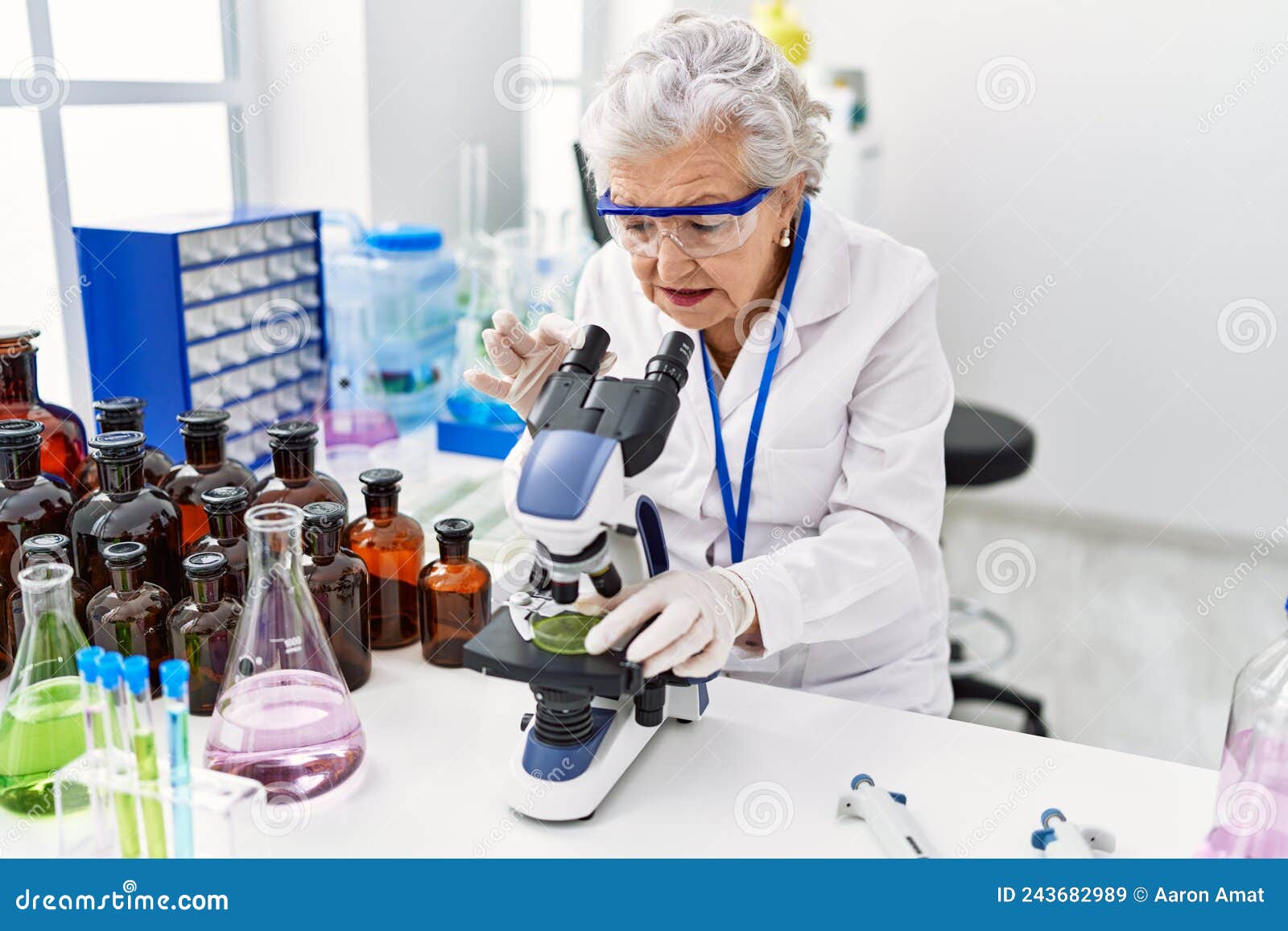 Senior Grey-haired Woman Wearing Scientist Uniform Using Microscope at ...