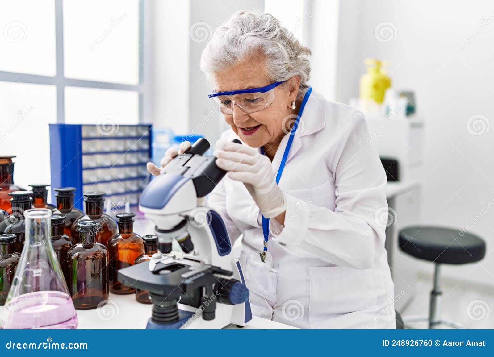 Senior Grey-haired Woman Wearing Scientist Uniform Using Microscope at ...