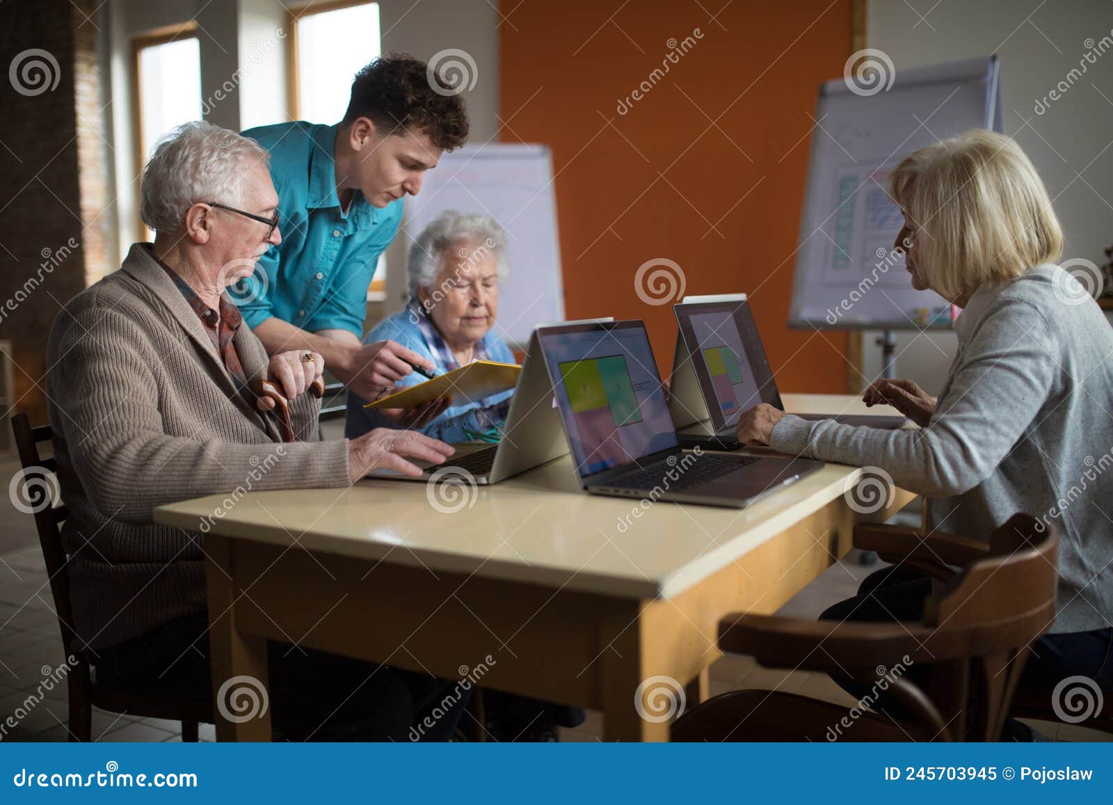 Senior Group in Retirement Home with Young Instructor Learning Together ...