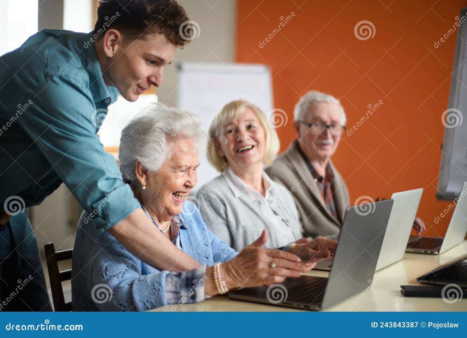 Senior Group in Retirement Home with Young Instructor Learning Together ...