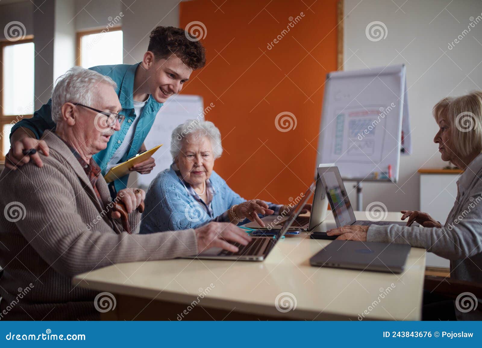 Senior Group in Retirement Home with Young Instructor Learning Together ...